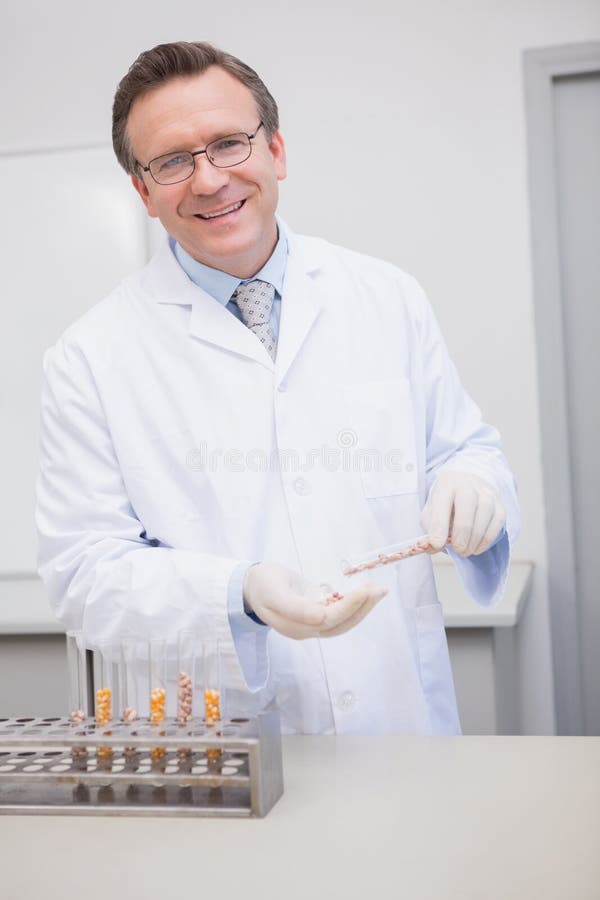 Happy Scientist Smiling at Camera Using Microscope Stock Photo - Image ...
