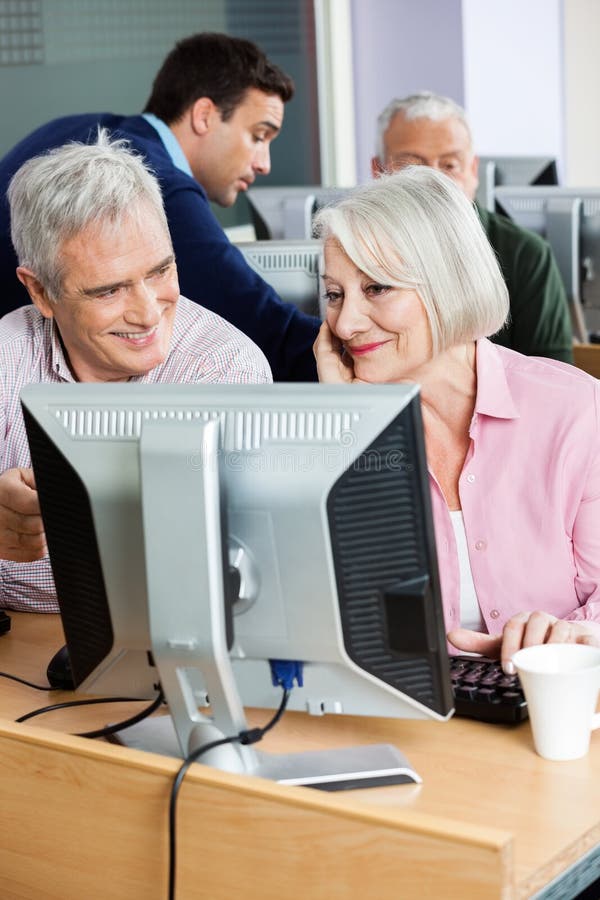 Senior Woman Sitting by Male Classmate during Computer Class Stock ...