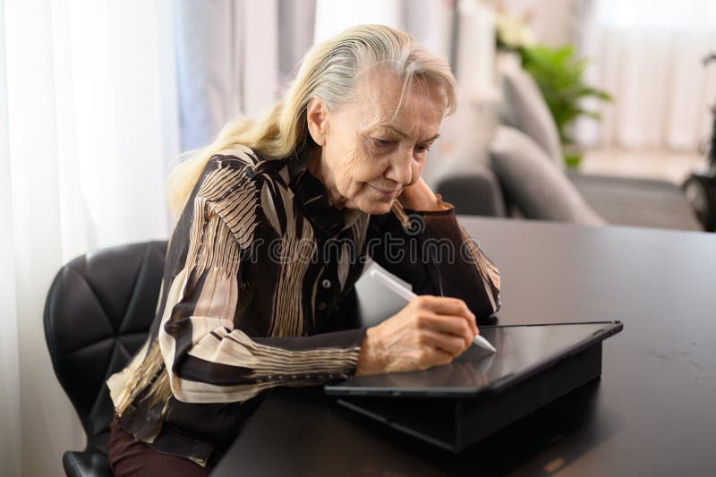 Happy Senior Grandmother Smiling And Sitting On Sofa At Home Stock