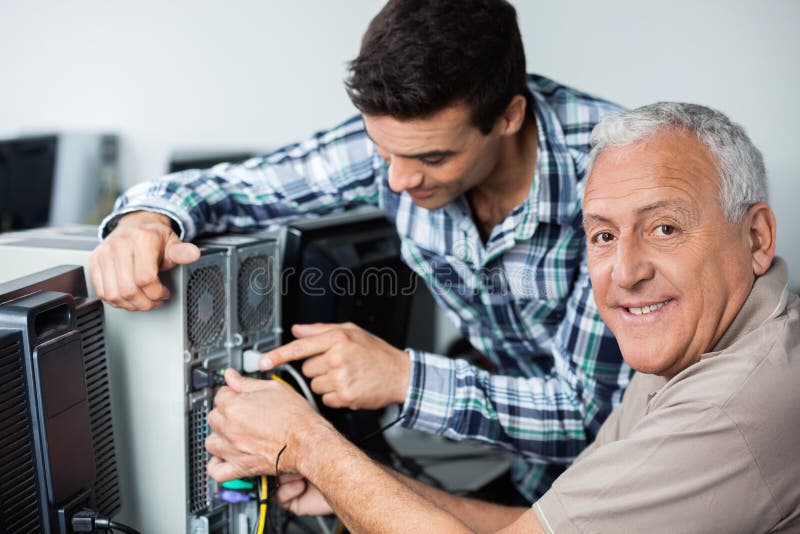 Happy Senior Man with Teacher Installing Computer in Classroom Stock ...