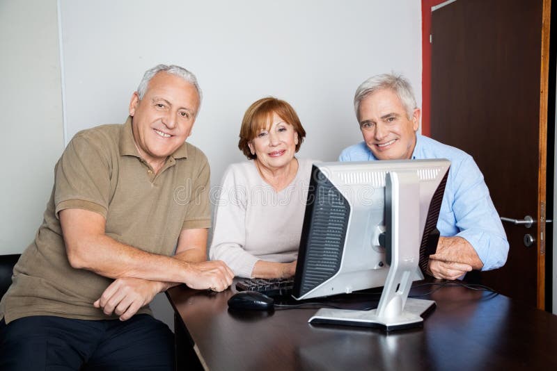 Happy Senior People Using Computer at Desk in Classroom Stock Photo ...