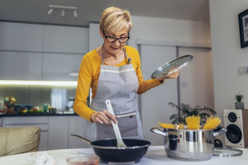 Senior Woman Cooking in Her Modern Kitchen Stock Image - Image of ...