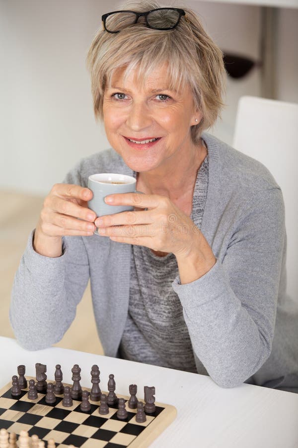 Happy Senior Woman Having Coffee while Playing Chess Stock Photo ...