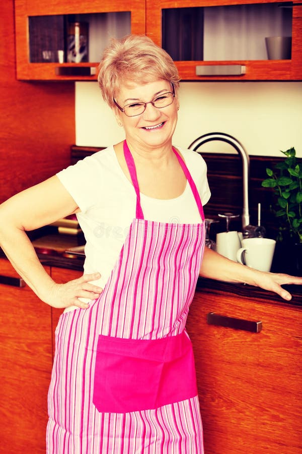 Happy Senior Woman Standing in Kitchen Stock Image - Image of cabinet ...