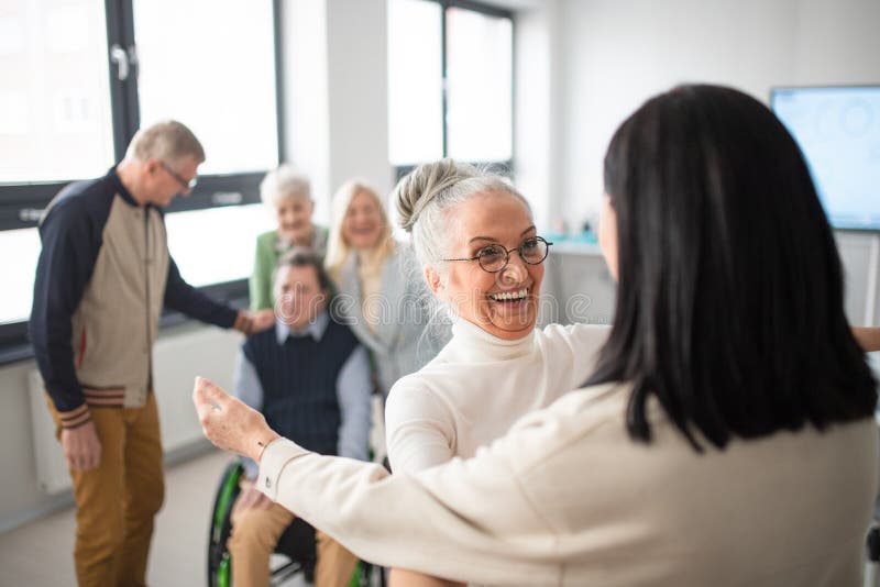 Happy Senior Women Students Meeting and Hugging in Classroom. Stock ...