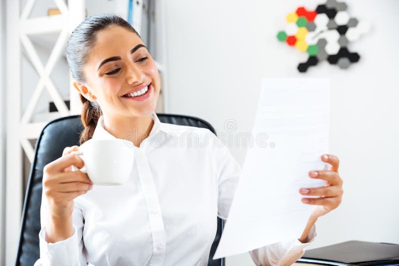 Happy Smiling Businesswoman Analysing Documents while Having Coffee ...