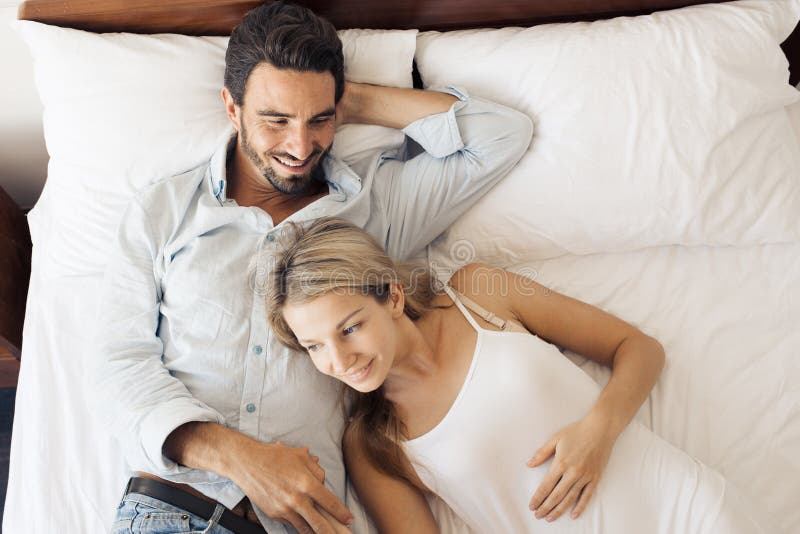 Happy Smiling Couple Lying on Bed in Bedroom Stock Photo - Image of ...