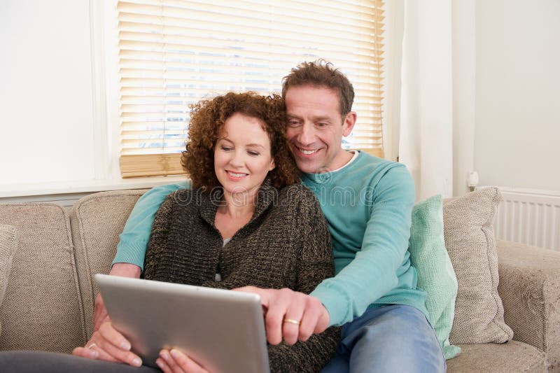 Happy Smiling Couple Using Computer Tablet at Home Stock Photo - Image ...