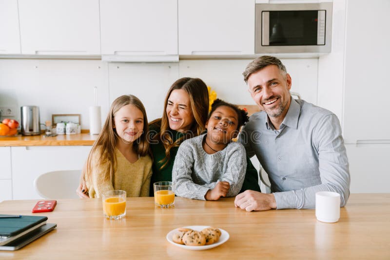 Happy Smiling Family Sitting at the Kitchen Table at Home Stock Photo ...