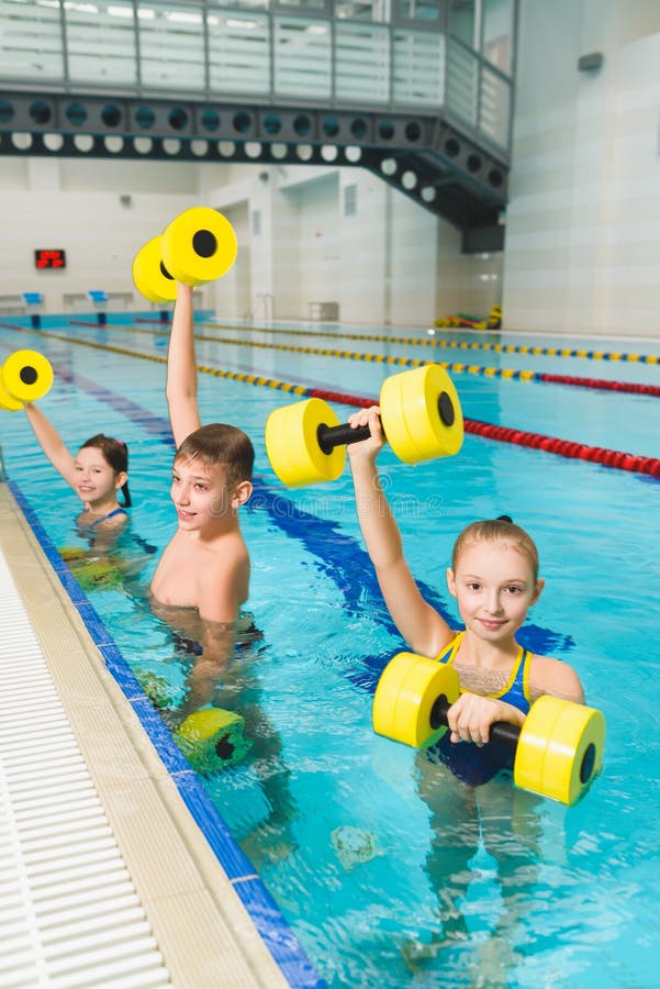 Happy and Smiling Group of Children Doing Exercises in a Swimming Pool ...