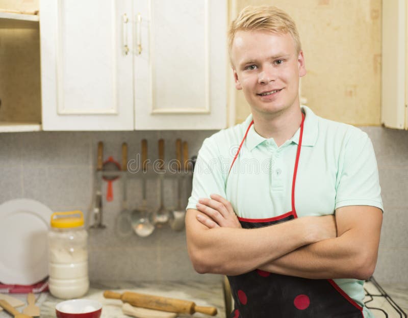 Happy Smiling Man Standing in the Kitchen with Folded Hands Stock Photo ...