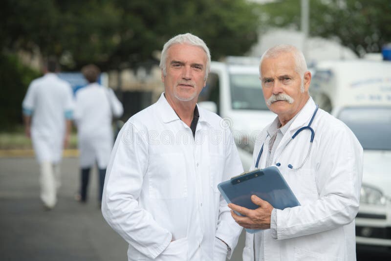 Two Senior Doctors Talking in Hospital Corridor Stock Photo - Image of ...
