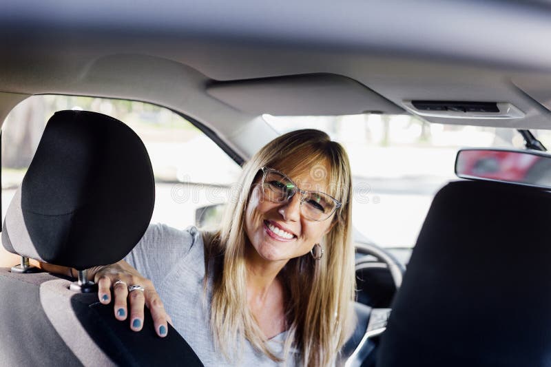 Woman Inside a Car Looking at Passengers in Back Seat Stock Photo ...