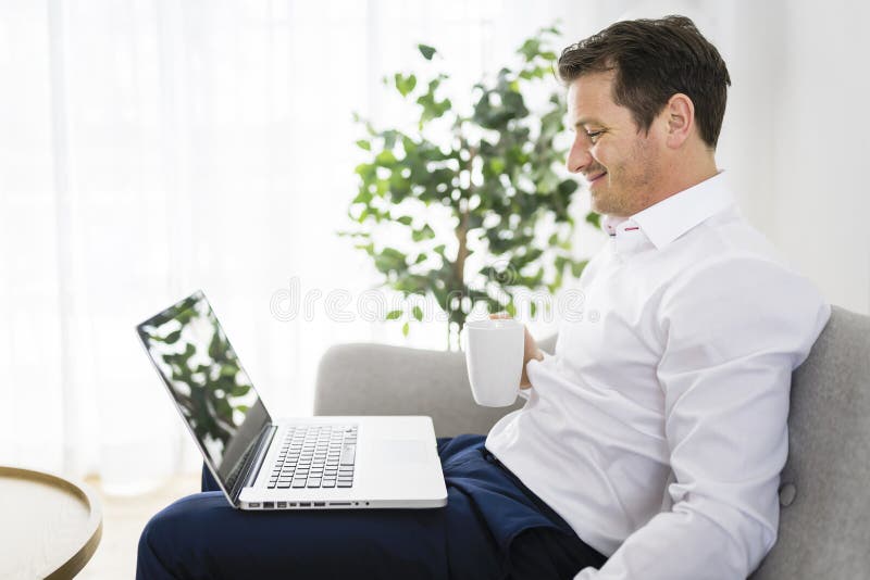 Happy Smiling Young Man Watching and Working on Computer Laptop at Home ...