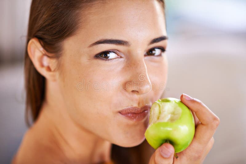 Happy Snacking. an Attractive Young Woman Biting into a Green Apple ...