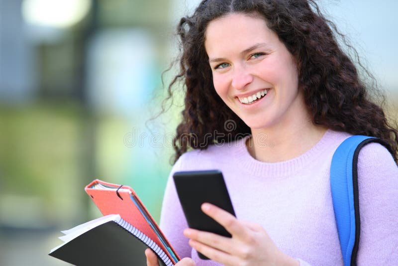 Happy Student Looking at Camera Holding Phone Stock Photo - Image of ...