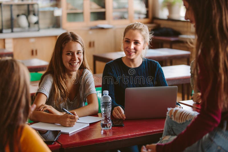 Happy Students Discussing Studies in Classroom Stock Photo - Image of ...