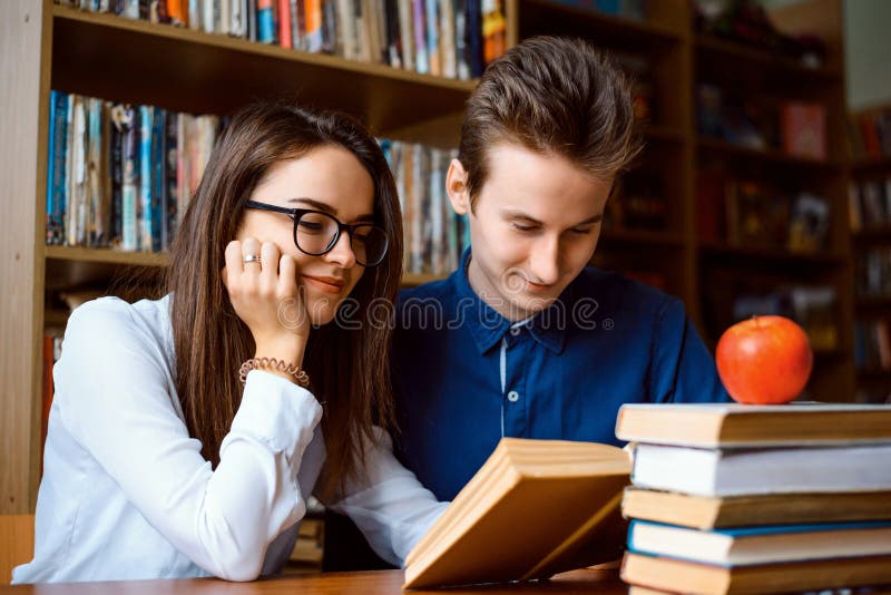 Happy Students Reading a Book in the Library Together Stock Image ...