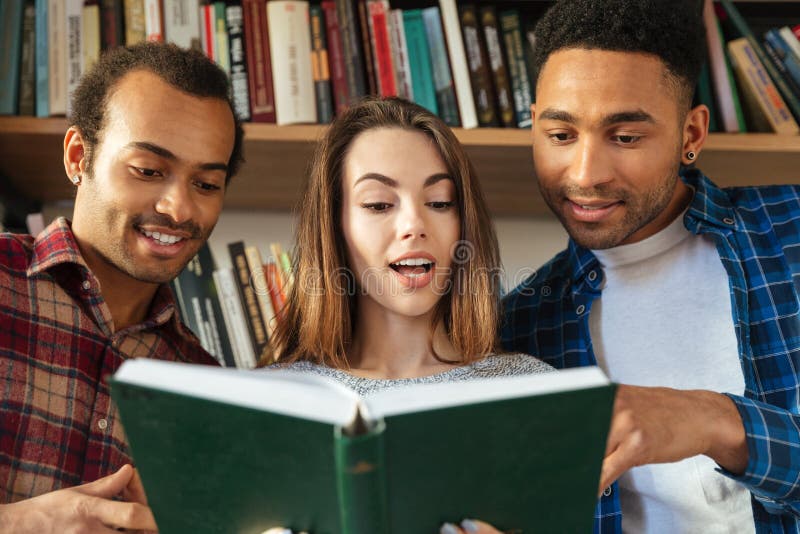 Happy Students Sitting in Library Reading Book. Stock Photo - Image of ...