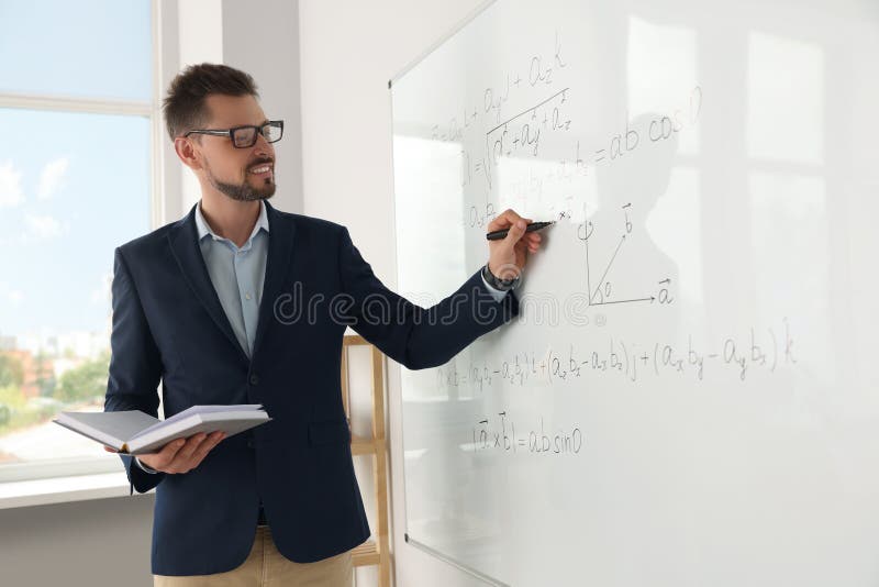 Happy Teacher with Book Explaining Mathematics at Whiteboard in ...