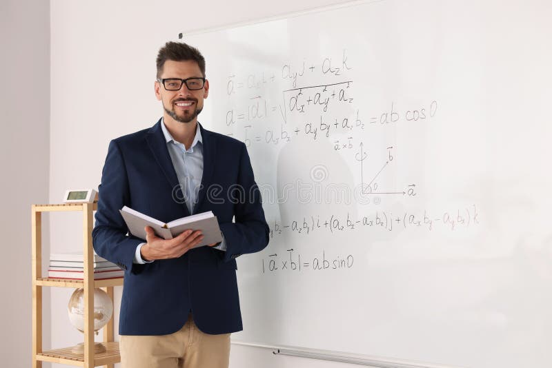 Happy Teacher with Book at Whiteboard in Classroom during Math Lesson ...