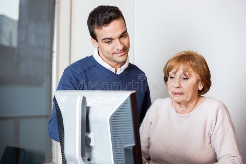 Happy Teacher Helping Senior Student in Computer Class Stock Image ...