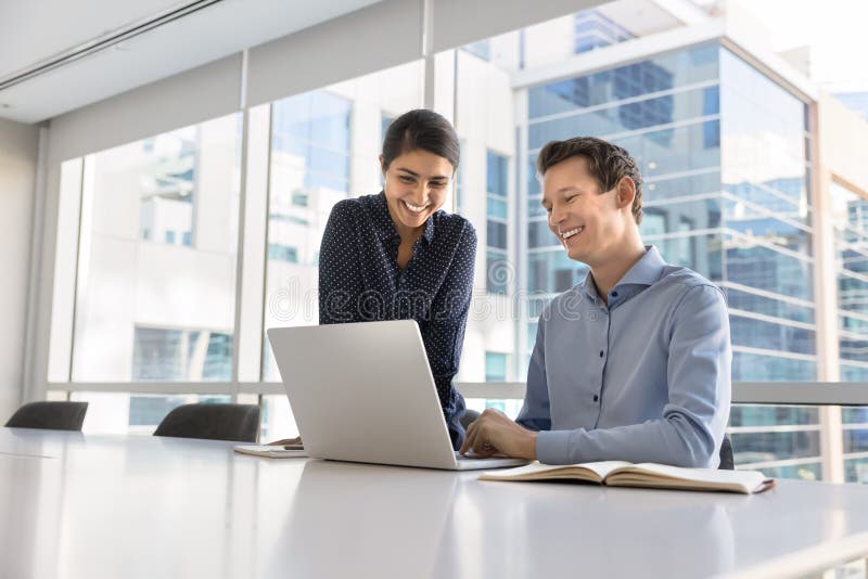 Happy Teammates Looking at Laptop Screen Engaged in Collaborative Task ...