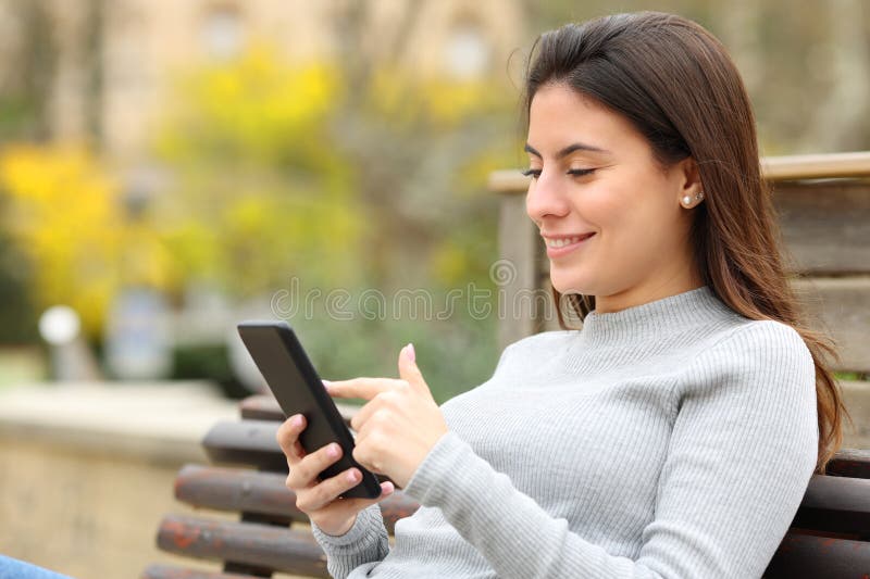 Happy Teen Using Smart Phone Sitting on a Bench Stock Photo - Image of ...