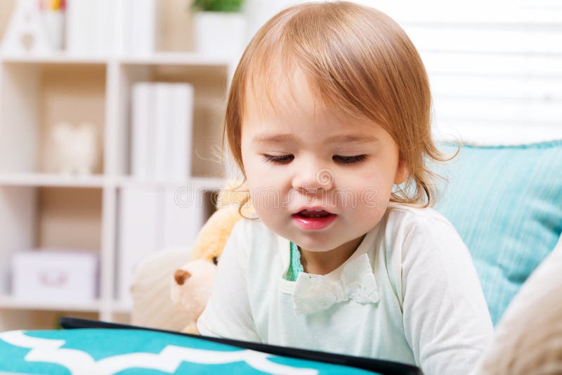 Happy Toddler Girl Watching Her Tablet Computer Stock Image - Image of ...