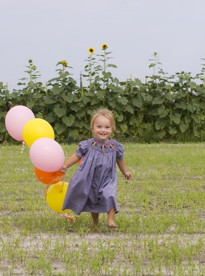 Happy Toddler Running with Balloons in Field Stock Photo - Image of ...