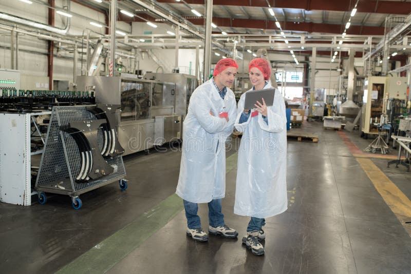 Happy Two Factory Workers in Uniform Examining Sample Stock Photo ...