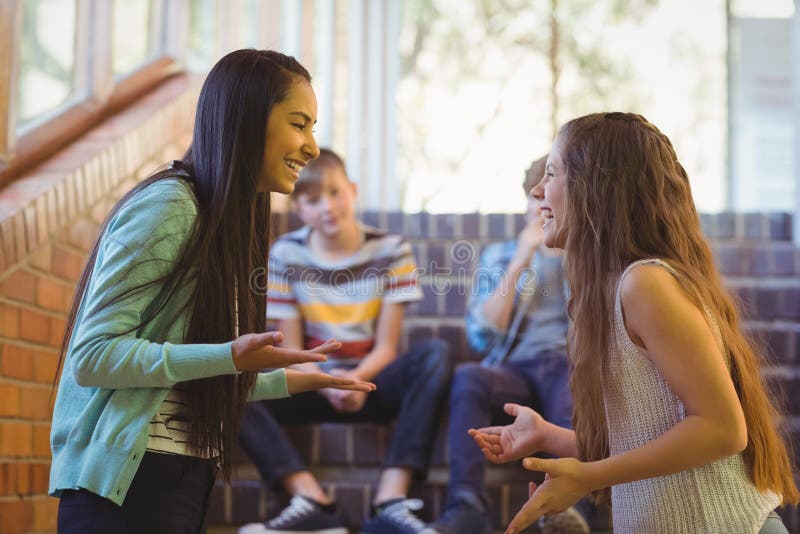 Happy Two Schoolgirls Interacting with Each Other in Corridor Stock ...