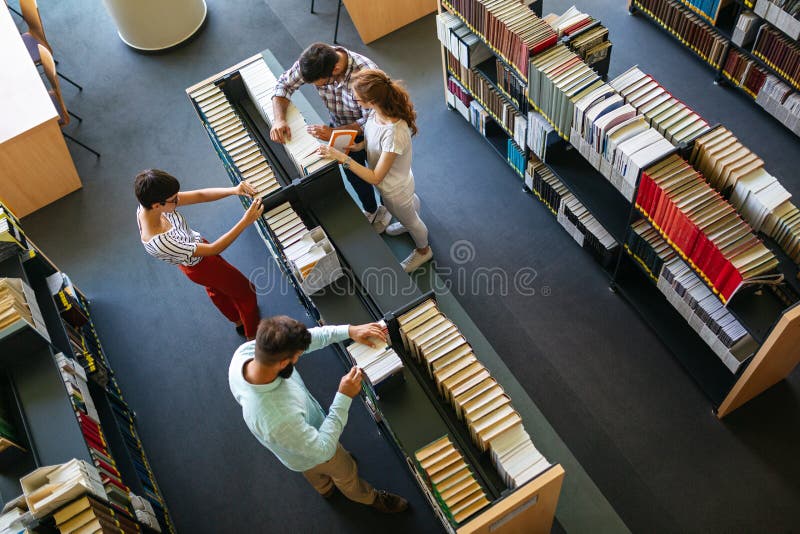 Happy University Students Studying with Books in Library. Group of ...