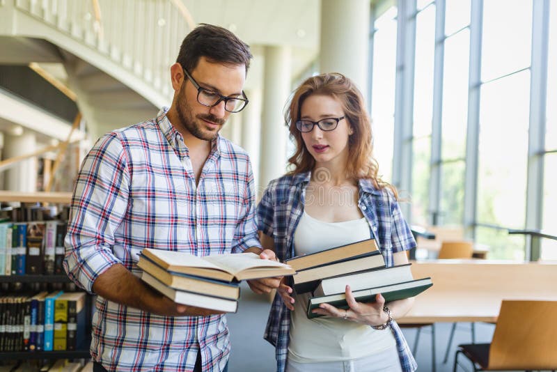 Happy University Students Studying with Books in Library. Group of ...