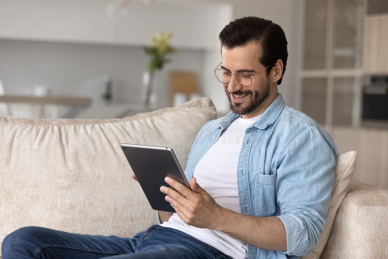Happy User Holding Digital Device, Resting on Couch Stock Image - Image ...
