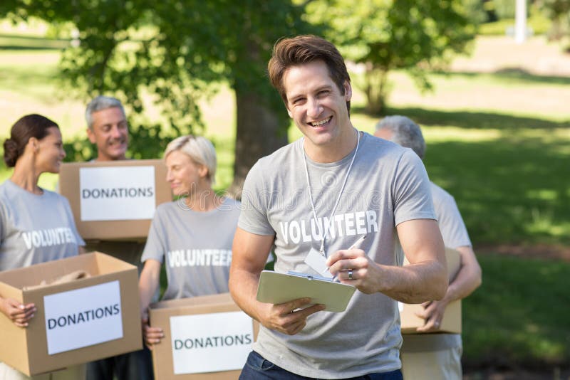 Happy Volunteer Man Writing in Clipboard Stock Photo - Image of ...