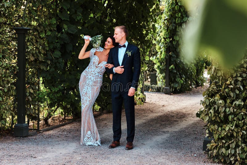 Happy Wedding Couple is Walking by a Beautiful Garden. Stock Photo ...