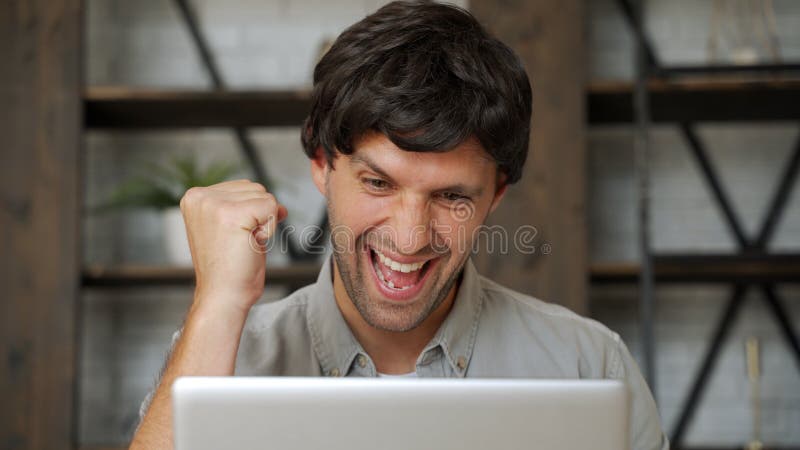Happy Winner. Young Excited Man Using Laptop Computer while Sitting on ...