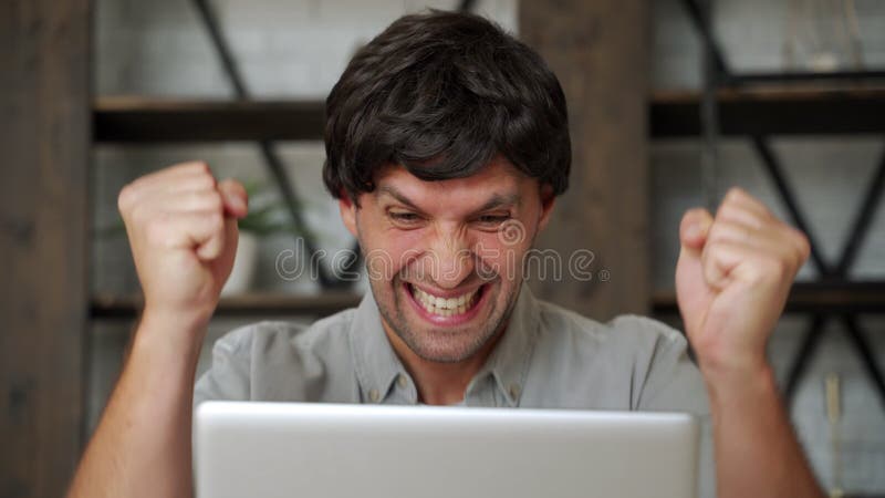 Happy Winner. Young Excited Man Using Laptop Computer while Sitting on ...