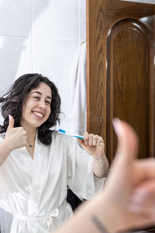 Happy Woman Brushing Her Teeth In The Bathroom Mirror Happy Girl