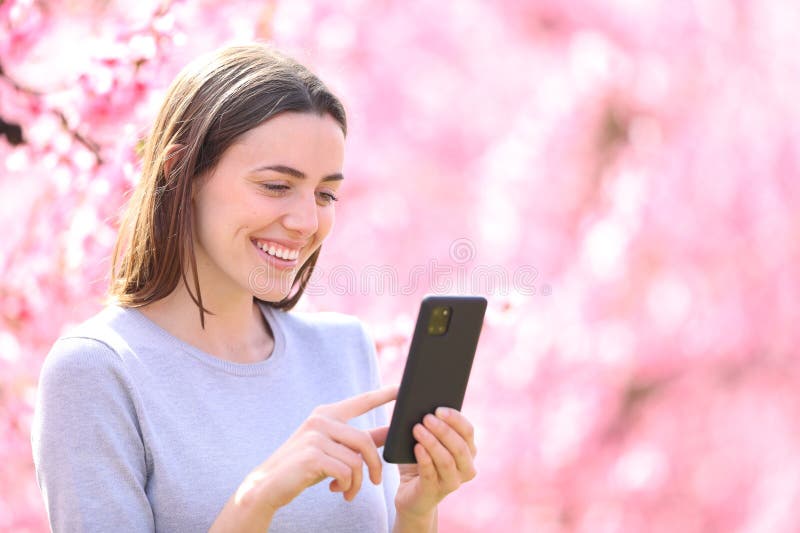 Happy Woman Checking Smart Phone in a Field Stock Photo - Image of ...
