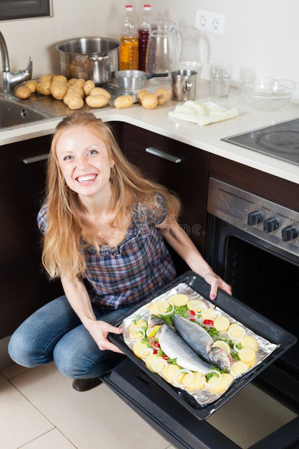 Happy Woman Cooking Raw Fish in Oven Stock Photo - Image of branzino ...