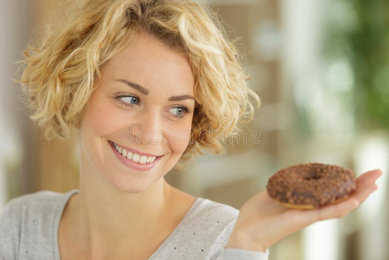 Happy woman eating donut stock image. Image of piece - 186440181