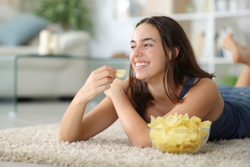 Happy Woman Eating Potato Chips on a Carpet at Home Stock Photo - Image ...