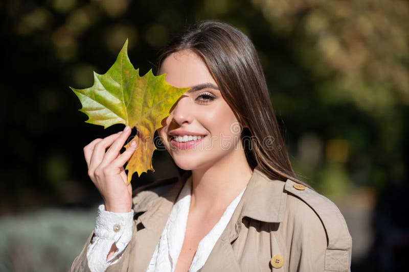 Happy Woman Holding Autumn Leafs On Face In Fall Nature Portrait Of