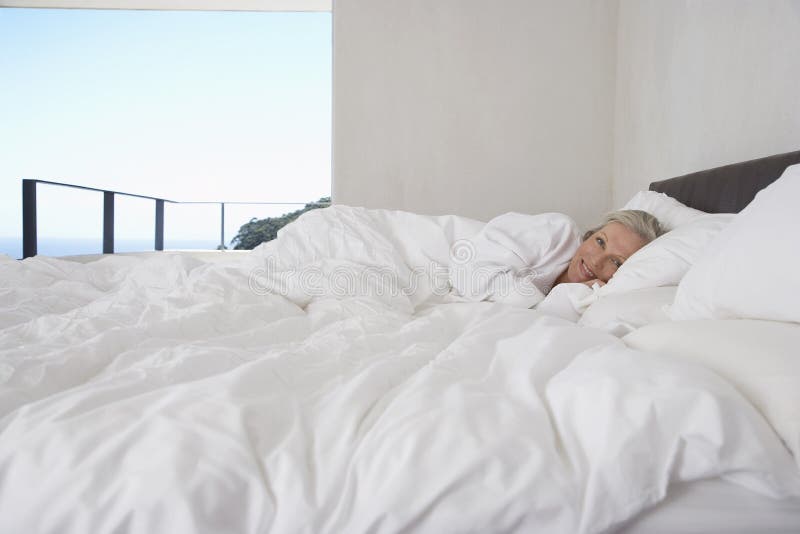 Happy Woman Lying in Bed stock photo. Image of people - 33827912
