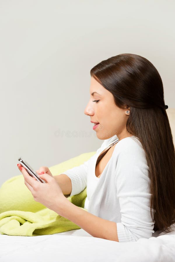 Happy Woman Lying on Bed Smiling, Reading a Text Message Stock Image ...