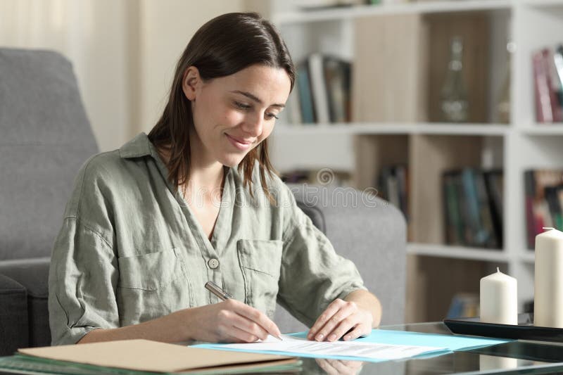 Happy Woman Reading and Signing Documents at Home Stock Image - Image ...