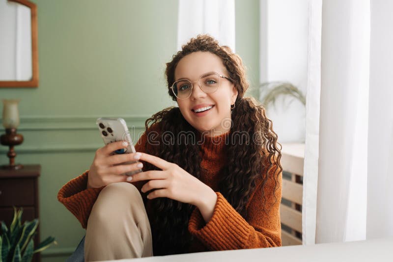 Happy Woman Using Cell Phone Technology at Home, Smiling while Checking ...