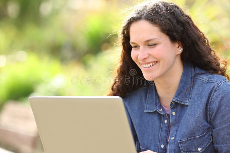 Happy Woman Using Laptop in a Park Stock Photo - Image of looking ...